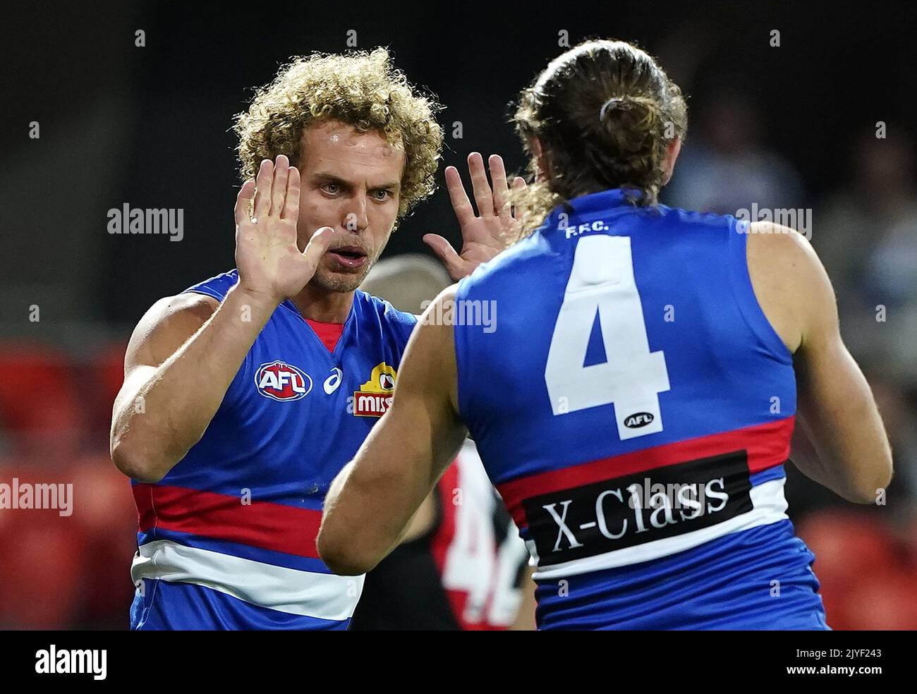Mitch Wallis of the Bulldogs (left) reacts after kicking a goal during ...