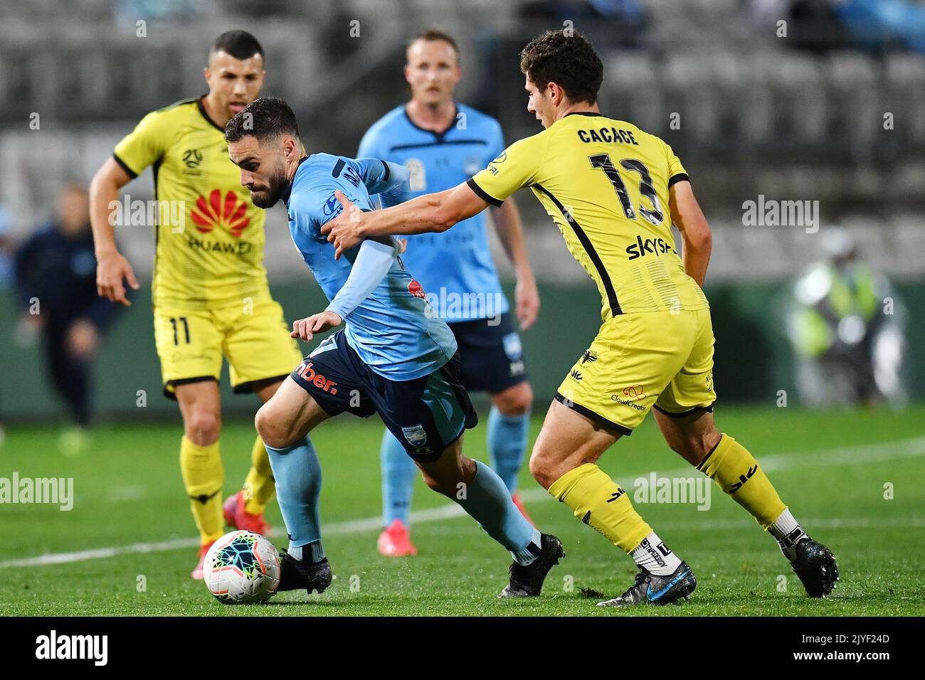 Anthony Caceres of Sydney comes under pressure from Liberato Cacace of ...