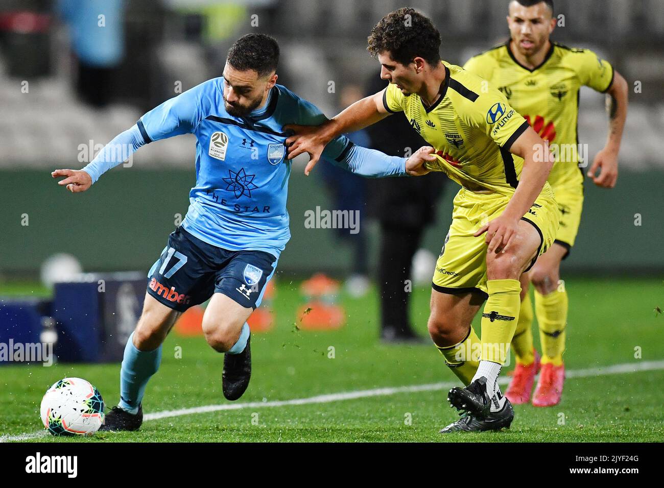 Anthony Caceres of Sydney comes under pressure from Liberato Cacace of ...