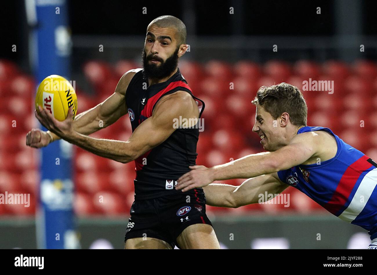 Adam Saad of the Bombers under pressure by Lachie Hunter of the ...