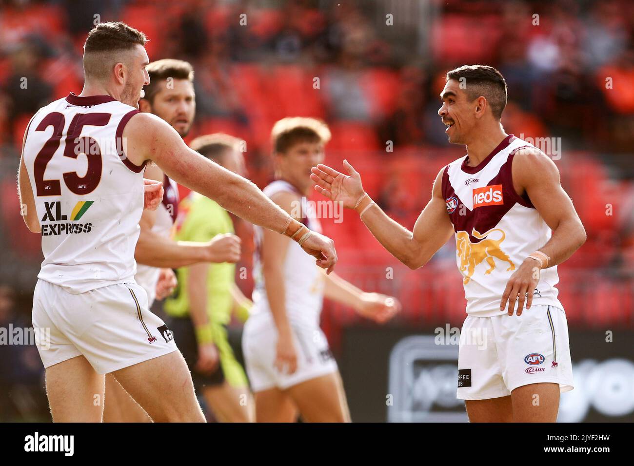 Charlie Cameron of the Lions celebrates kicking a goal with team mate ...