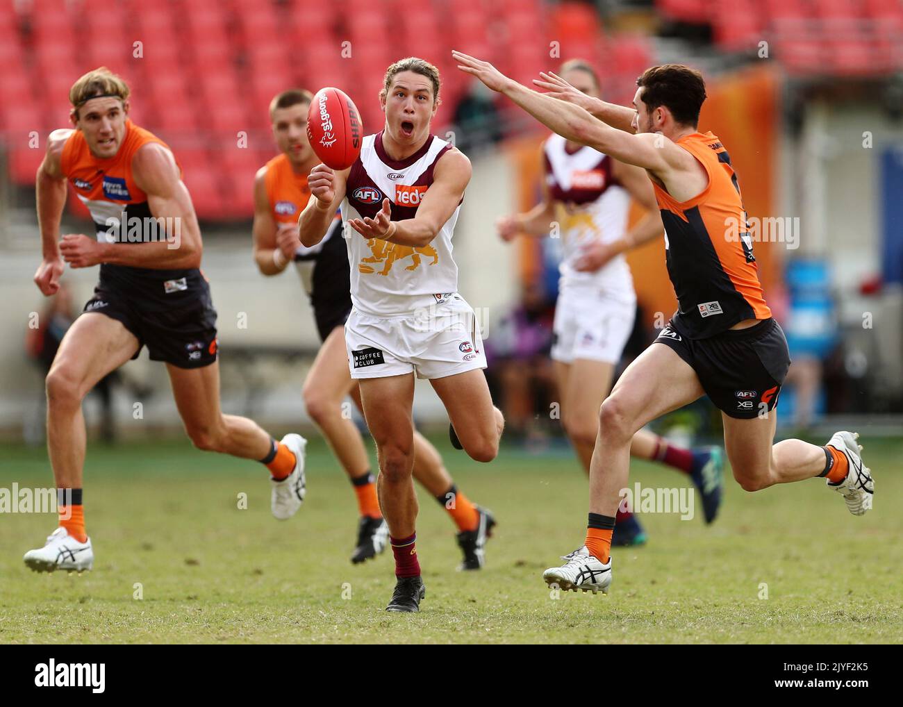 Thomas Berry of the Lions handpasses the ball to a team mate during the ...