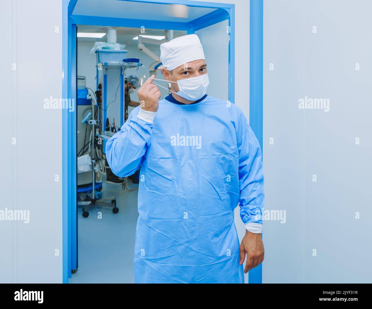 The male surgeon removes the surgical mask as he exits the operating ...
