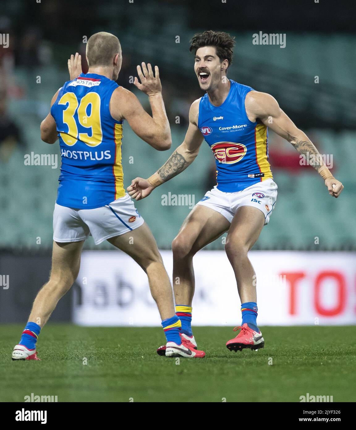 Nick Holman of the Suns (left) celebrates after kicking a goal during ...