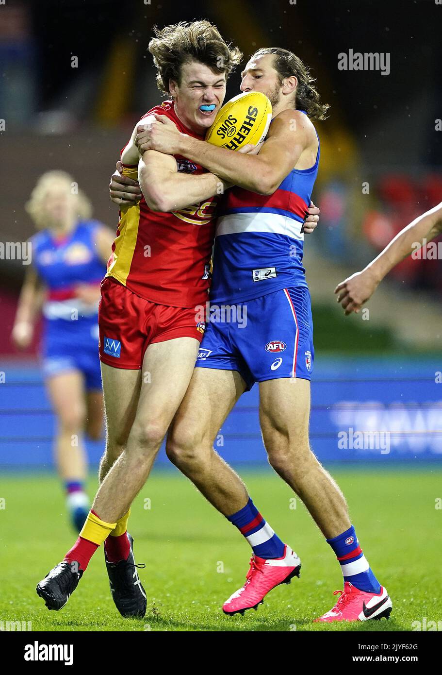 Marcus Bontempelli of the Bulldogs tackles Charlie Ballard of the Suns ...