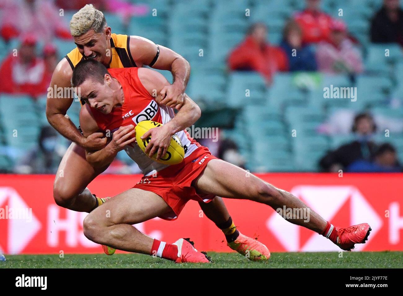 Matthew Ling of the Swans is tackled by Darren Minchington of the Hawks ...