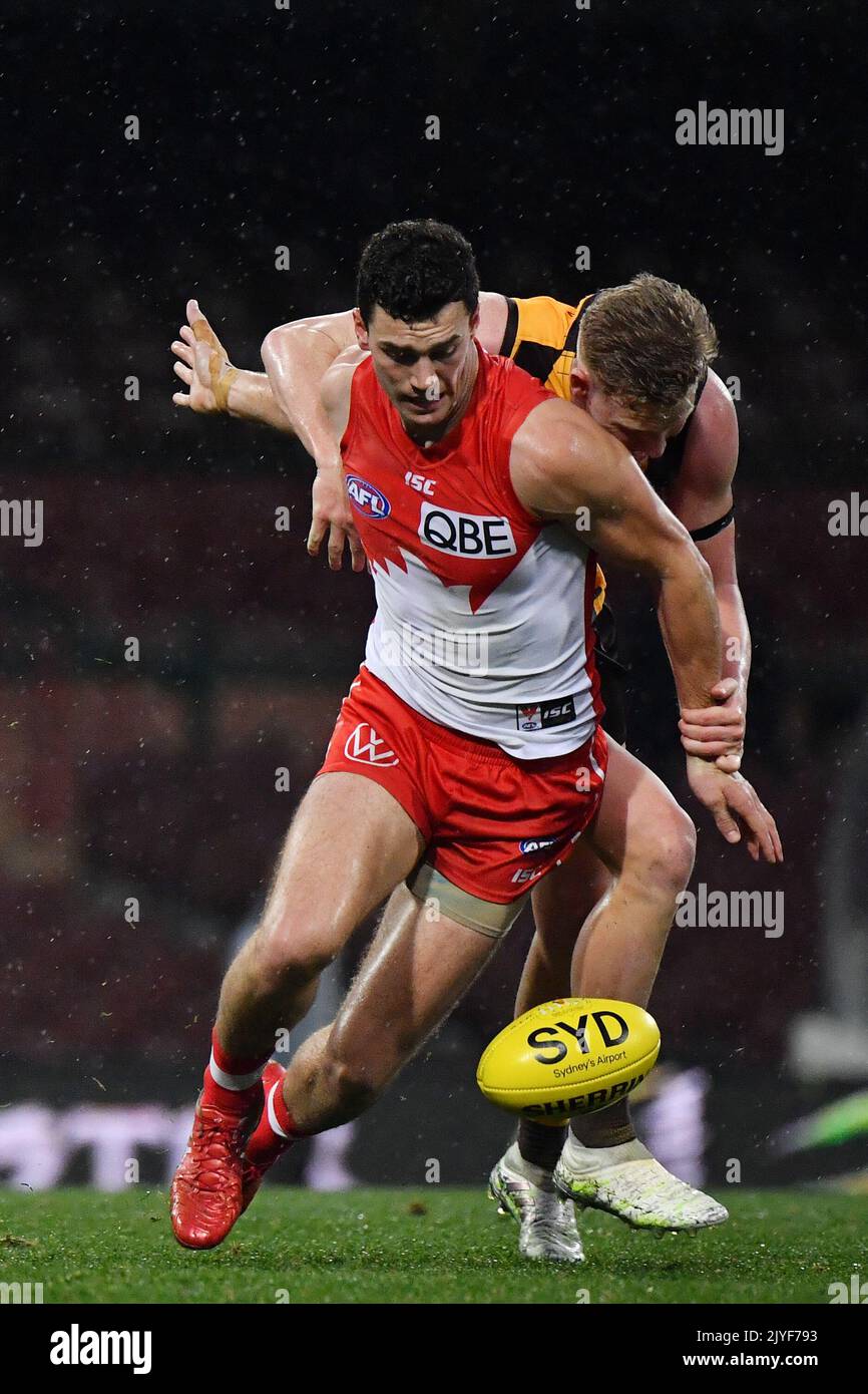 Tom McCartin of the Swans is held off the ball by James Sicily of the ...