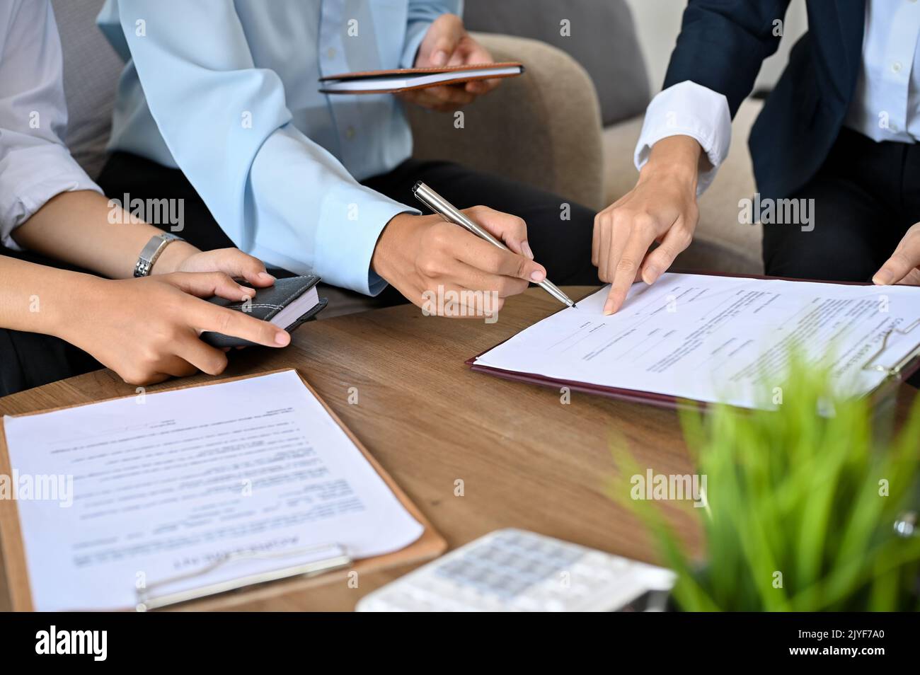 An Asian businessman signs his signature on a contract agreement paper ...