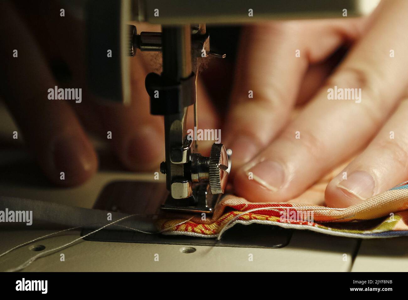 A detail view of Janet making masks which they are providing free for ...
