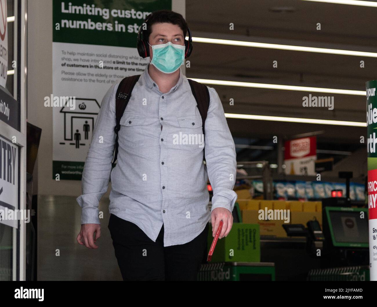 A shopper wearing a face mask leaving a Woolworths shop in Sydney ...