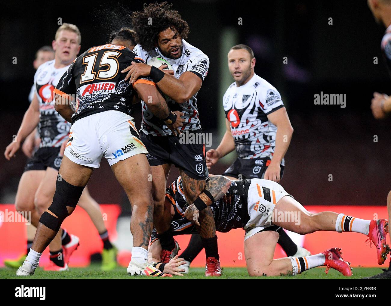 Adam Blair of the Warriors is tackled by Thomas Mikaele (left) and Sam ...