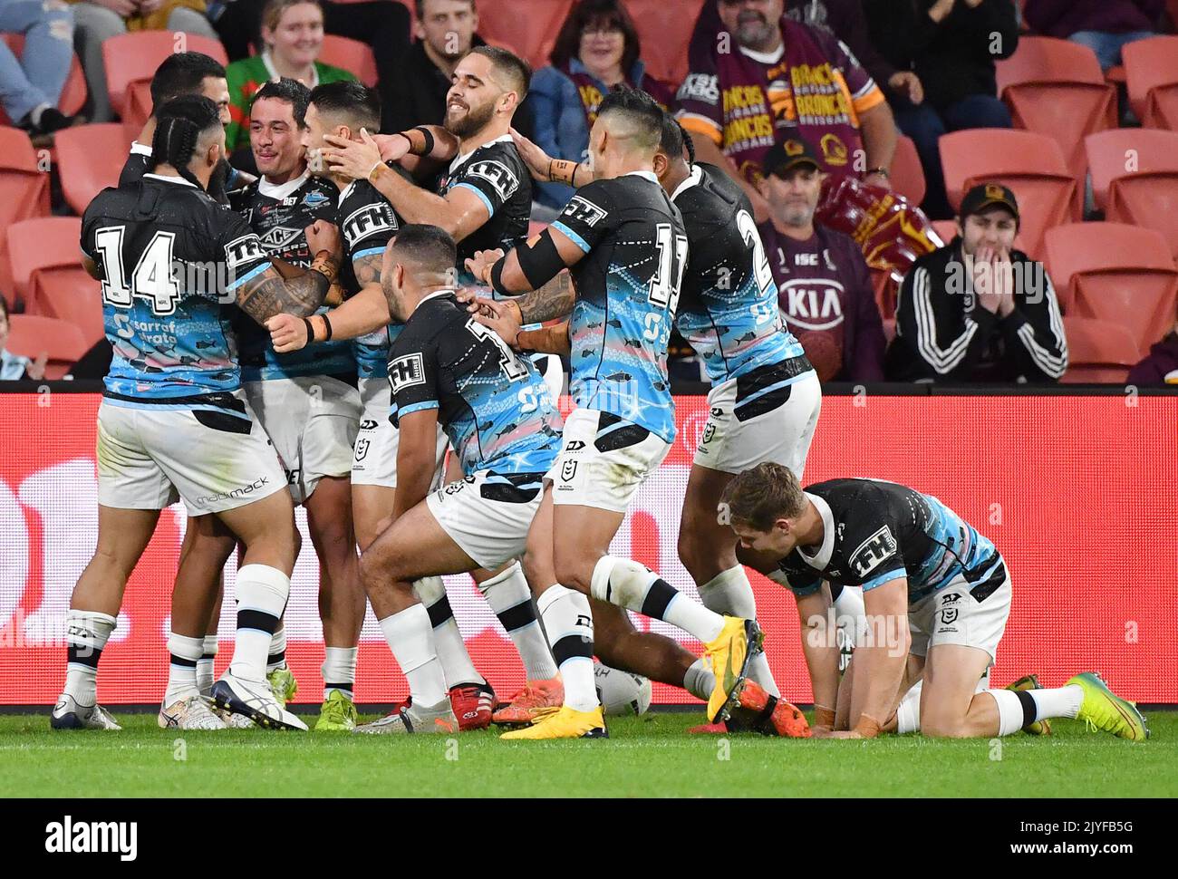 Jackson Ferris (centre) of the Sharks celebrates scoring a try with ...