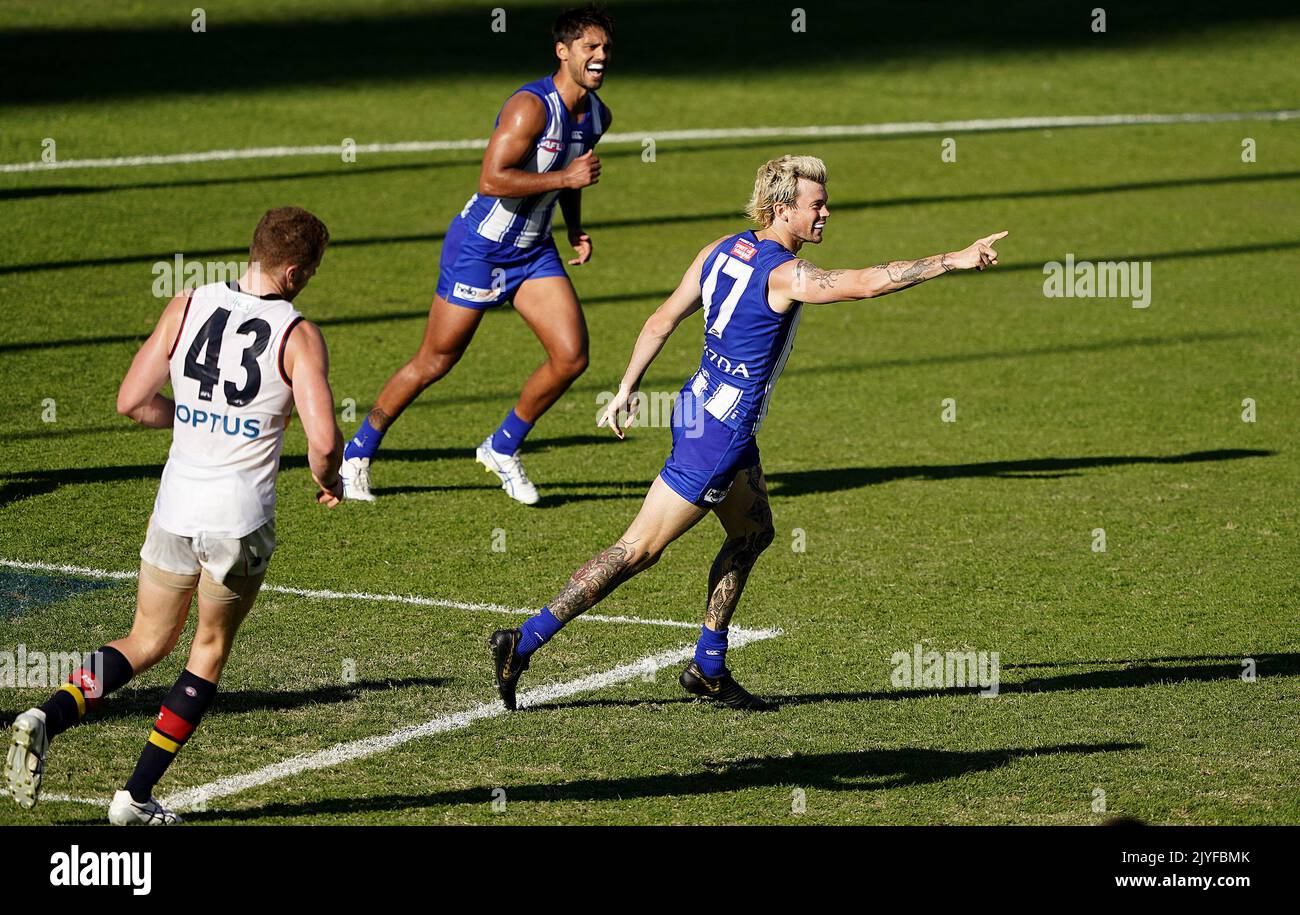 Jasper Pittard of the Kangaroos (right) reacts after kicking a goal ...