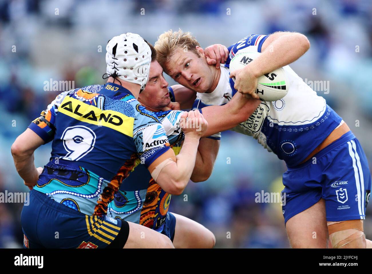 Aiden Tolman of the Bulldogs is tackled by Clint Gutherson of the Eels ...