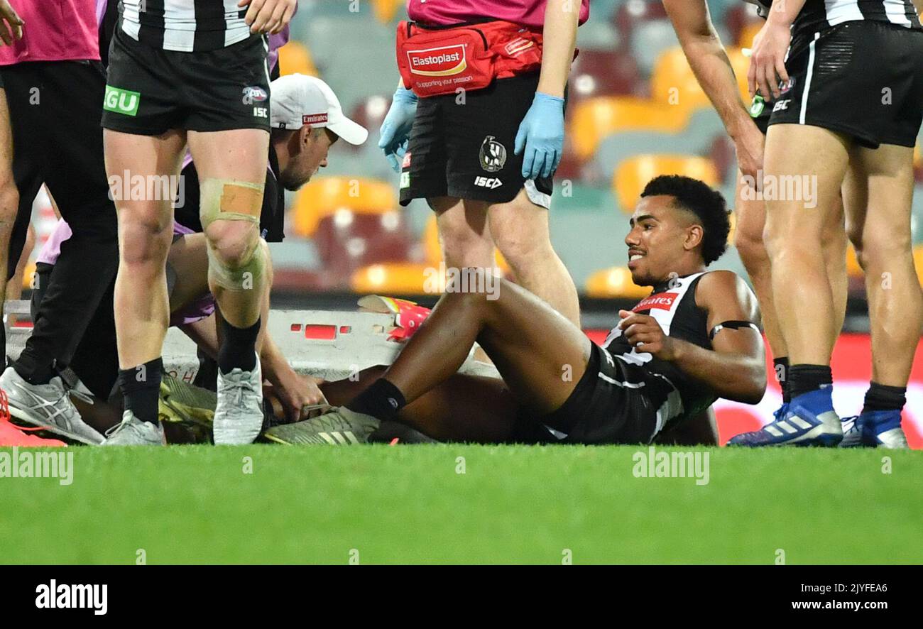 Isaac Quaynor of the Magpies is seen being treated for an injury during ...