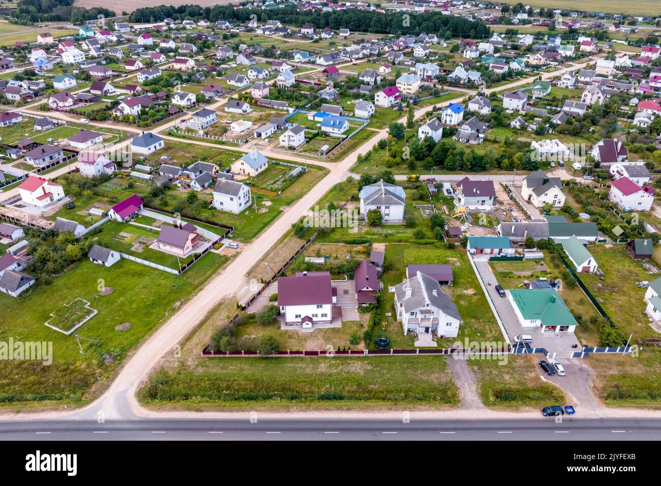 aerial panoramic view of green village with houses, barns and gravel ...