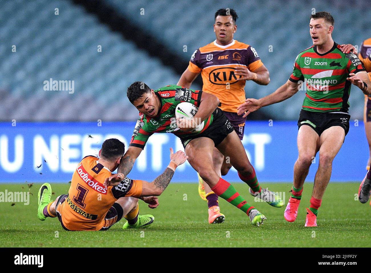 Latrell Mitchell of the Rabbitohs steps through a tackle by Darius Boyd ...