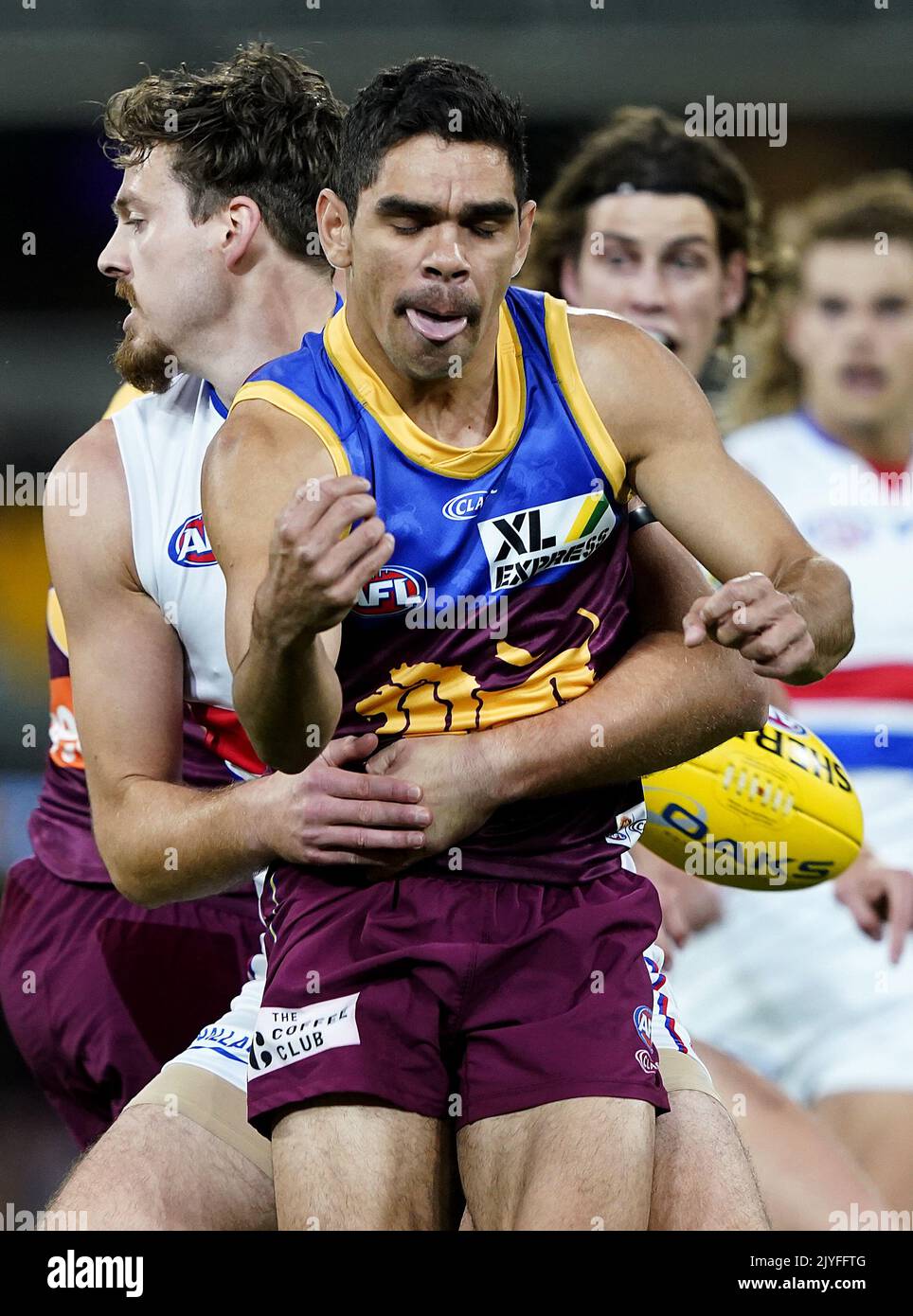 Charlie Cameron of the Lions is tackled by Zaine Cordy of the Bulldogs ...