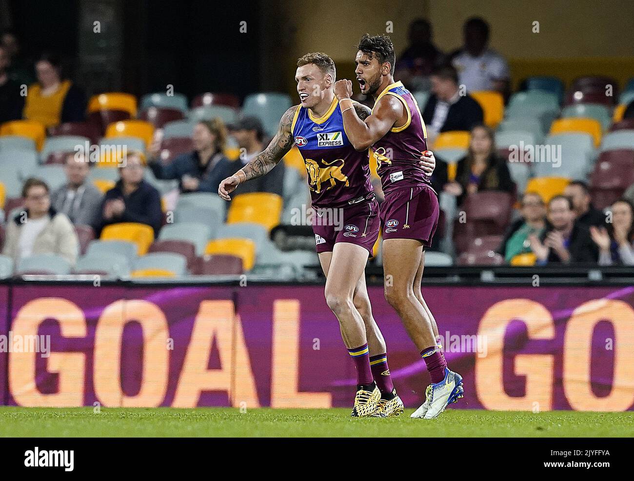 Callum Ah Chee of the Lions reacts with Mitch Robinson after kicking a ...