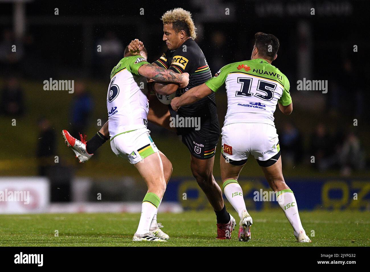 Villiame Kikau of the Panthers is tackled by Ryan Sutton (left) and ...