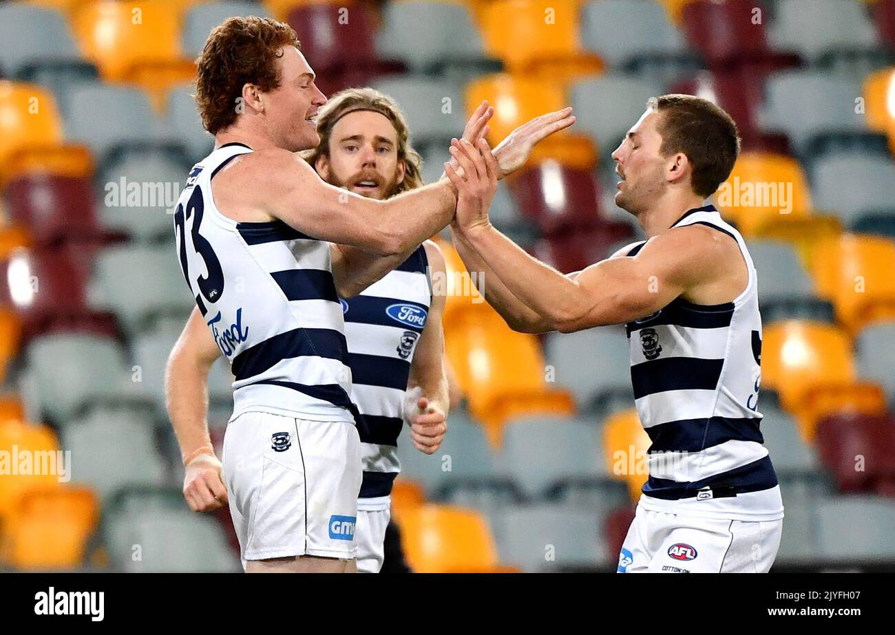 Gary Rohan (left) of the Cats celebrates kicking a goal with team mates ...
