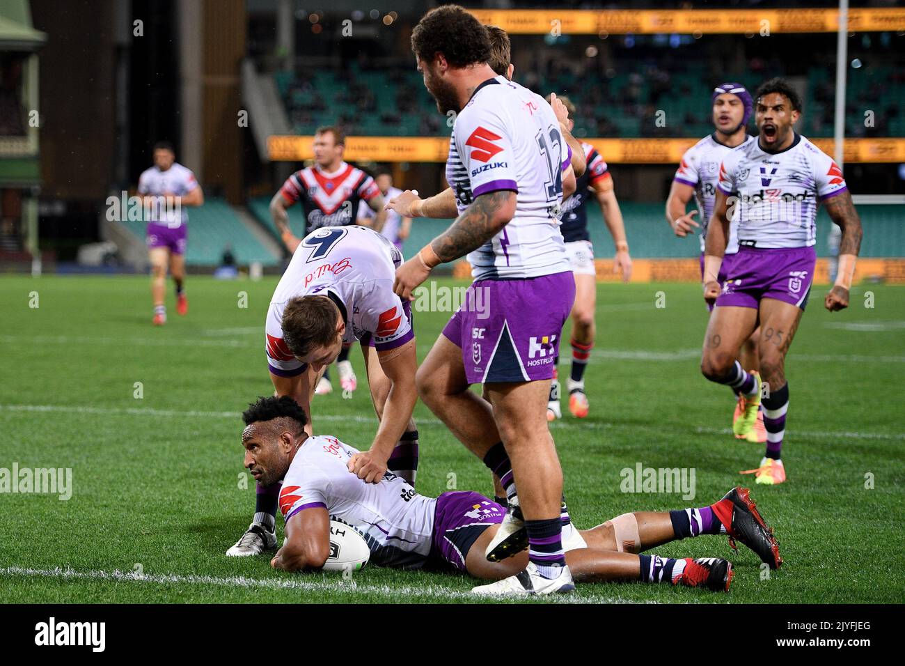 Justin Olam of the Storm celebrates with teammates after scoring a try ...