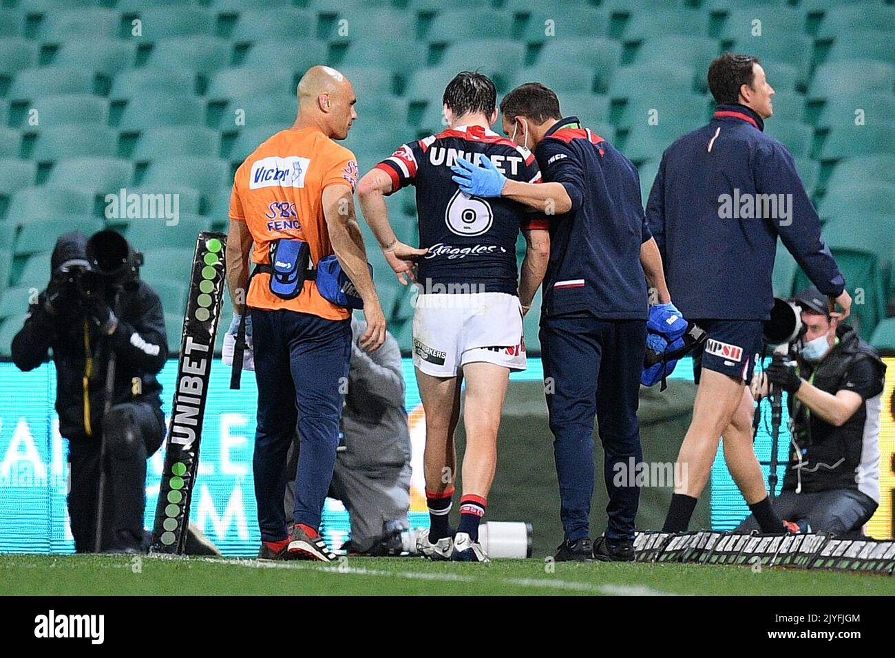 Luke Keary of the Roosters is assisted from the field after sustaining ...