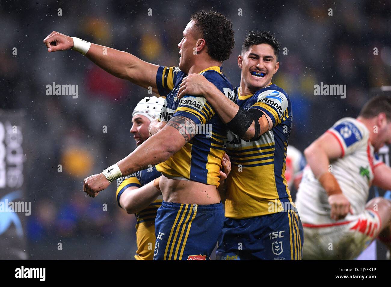 Kane Evans of the Eels (left) celebrates with teammates after scoring a ...