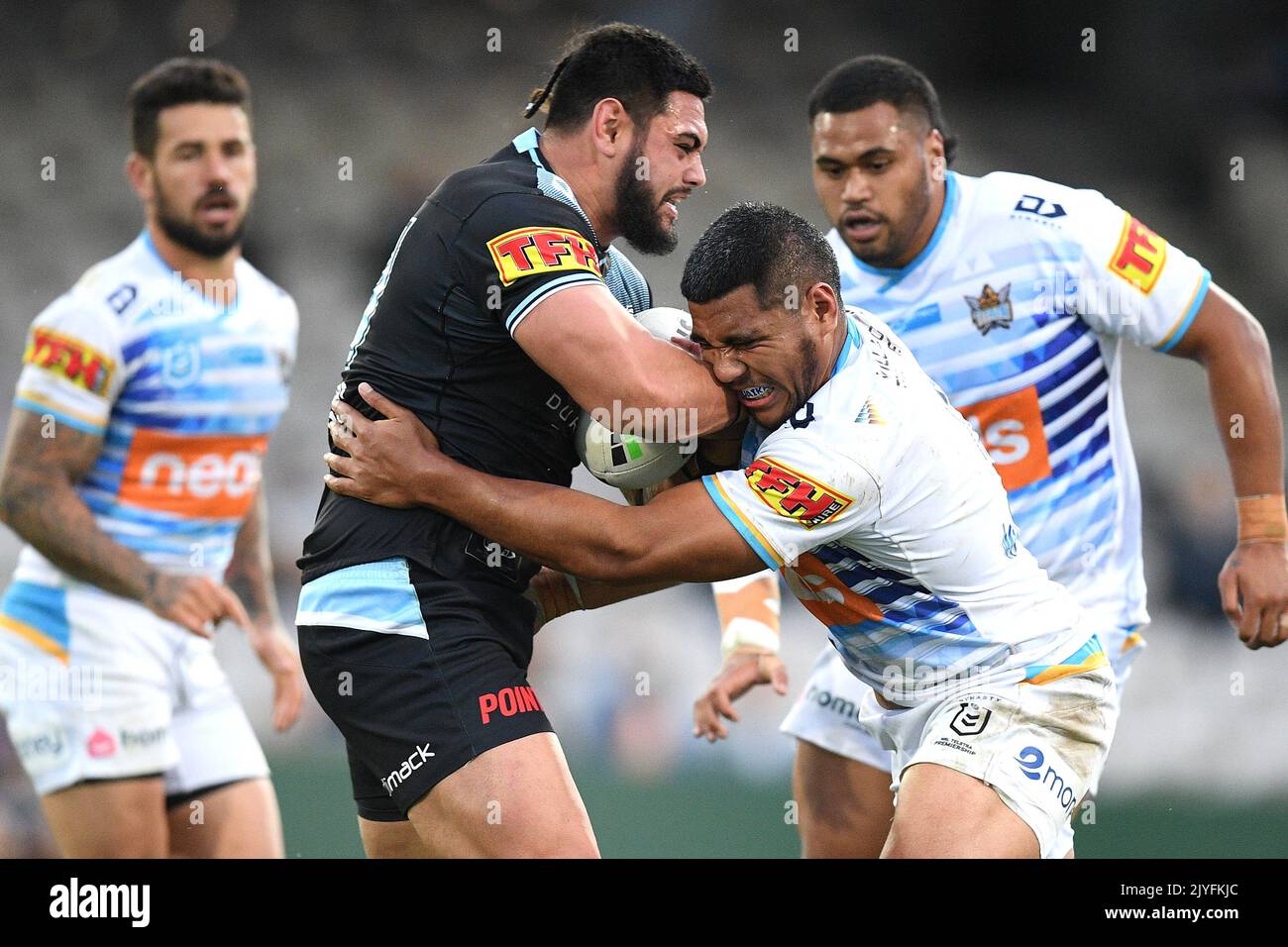 Royce Hunt of the Sharks is tackled by Moeaki Fotuaika of the Titans ...