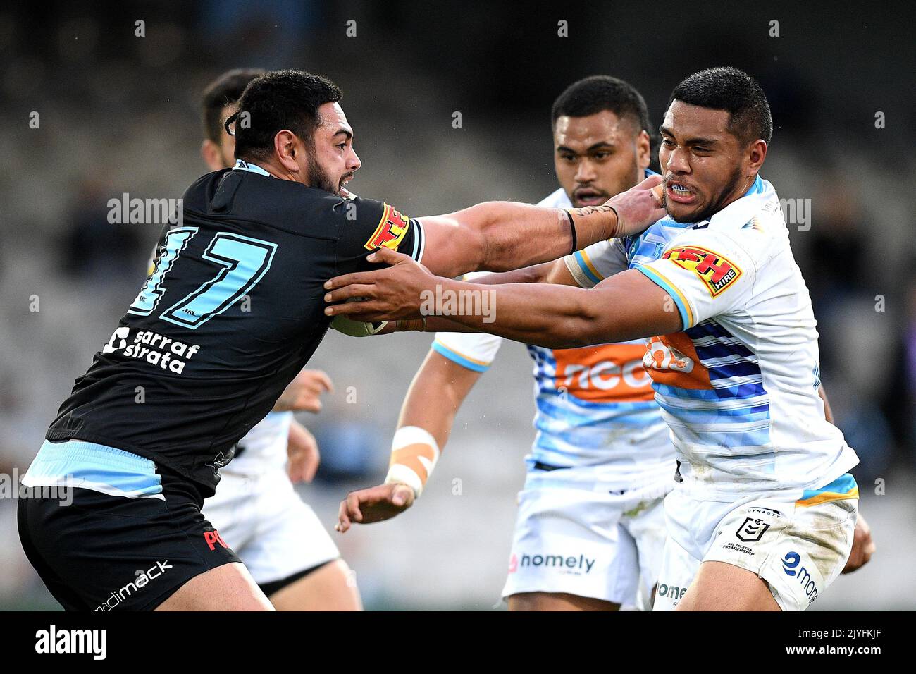 Royce Hunt of the Sharks fends off a tackle by Moeaki Fotuaika of the ...