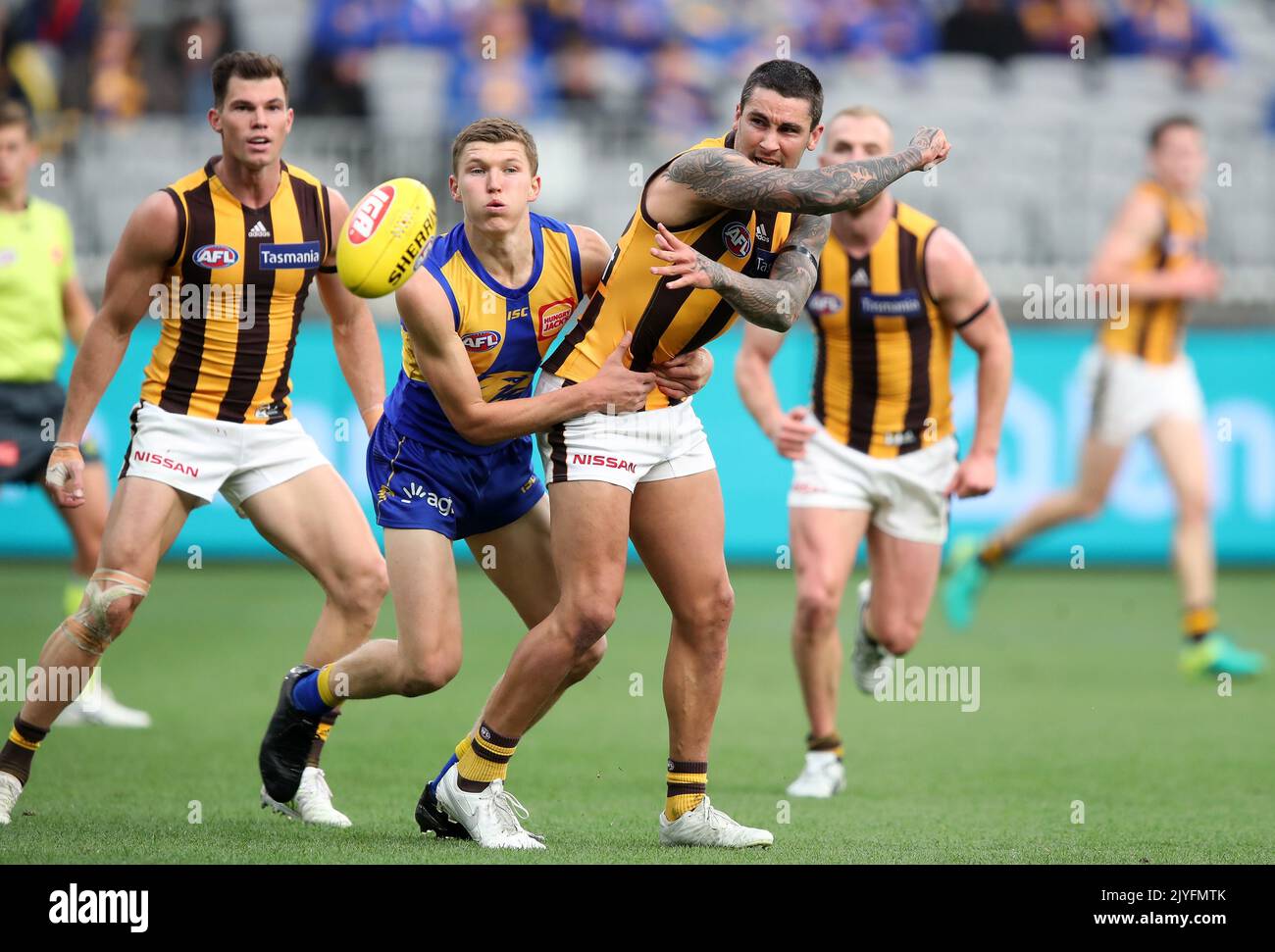 Chad Wingard of the Hawks makes a hand pass under pressure from Brayden ...