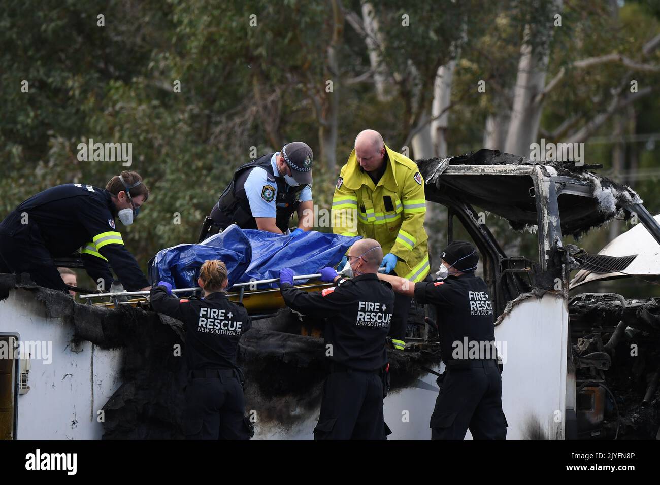 NSW Police, Forensic officers and Fire and Rescue Officers retrieve a body from the scene of a ...