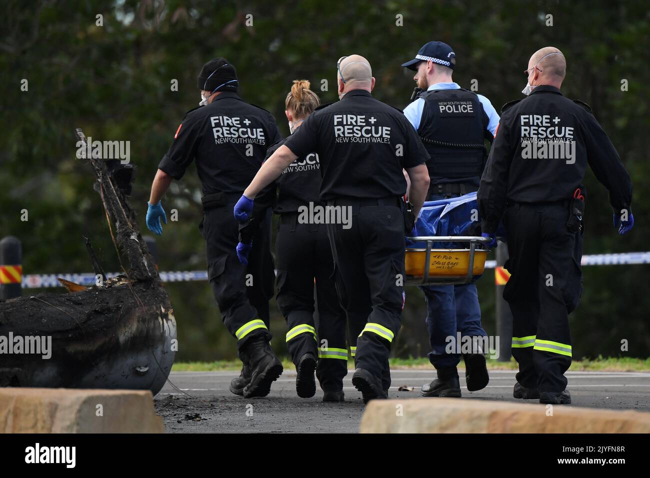 NSW Police, Forensic officers and Fire and Rescue Officers retrieve a body from the scene of a ...