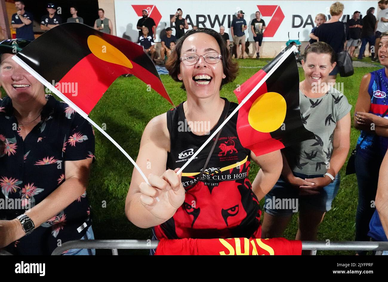 Spectator Angela Green displays the Aboriginal flag as she looks on ...