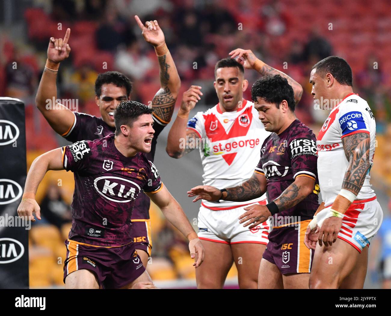 Cory Paix (centre) of the Broncos celebrates scoring a try during the ...
