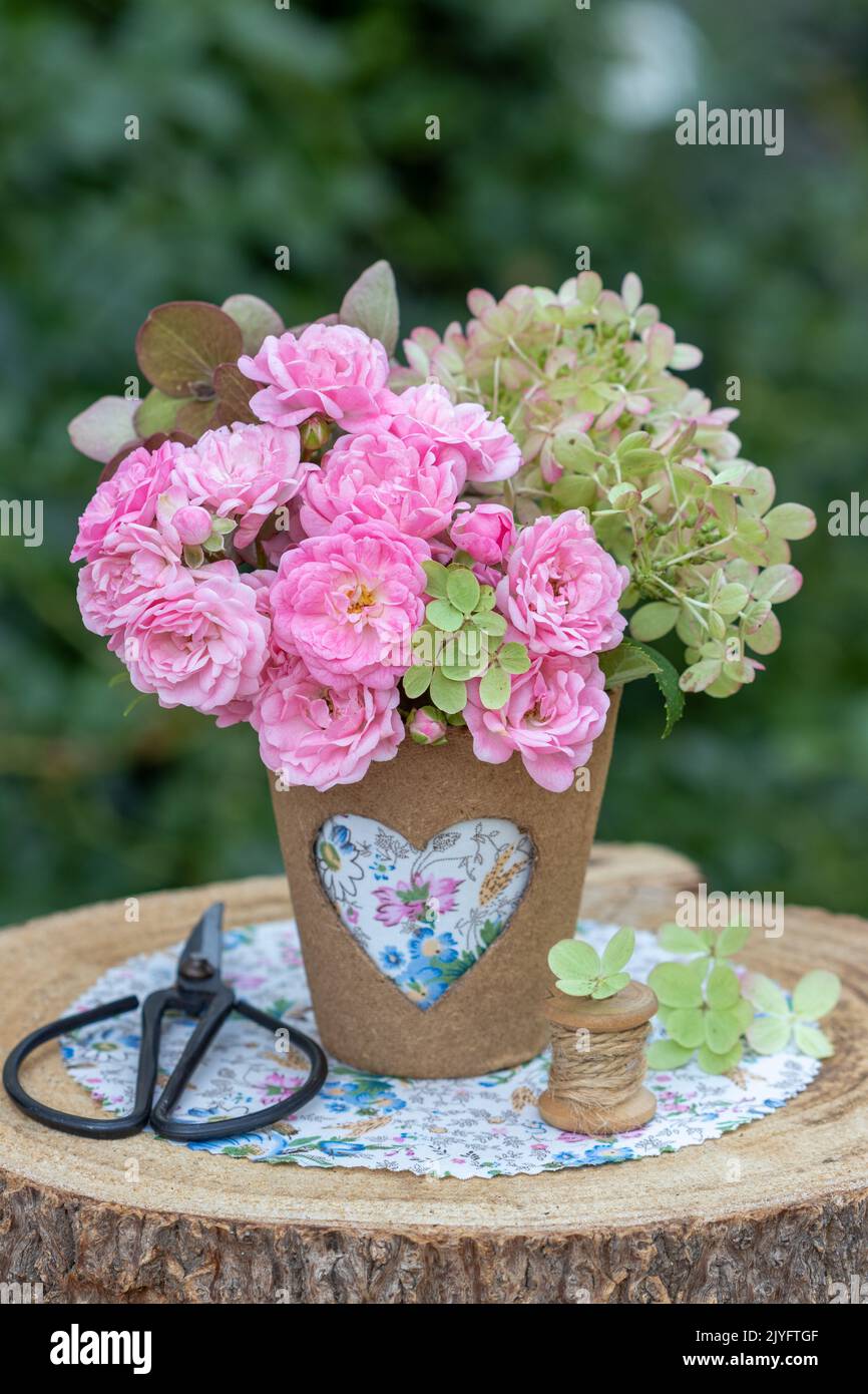 bouquet of pink roses and hydrangea flowers in biodegradable pot with ...