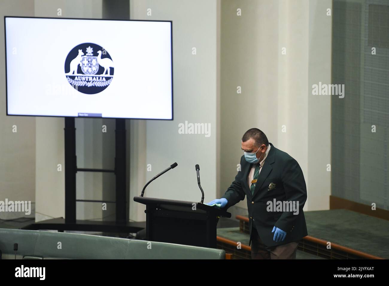 An attendant cleans a lectern ahead of House of Representatives ...