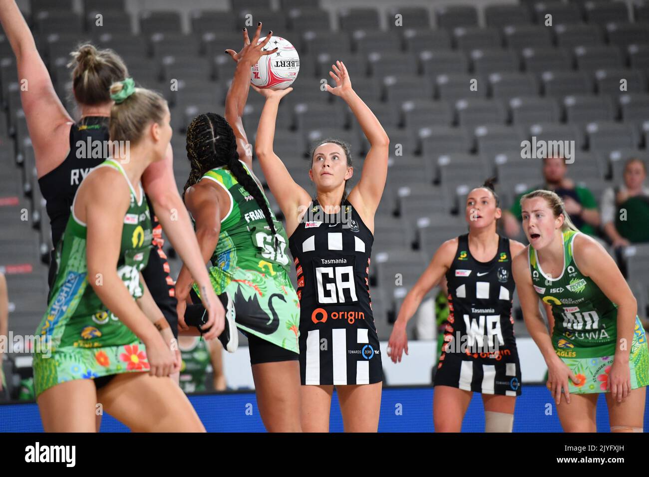 Gabrielle Sinclair (centre) of the Magpies shoots for goal during the ...