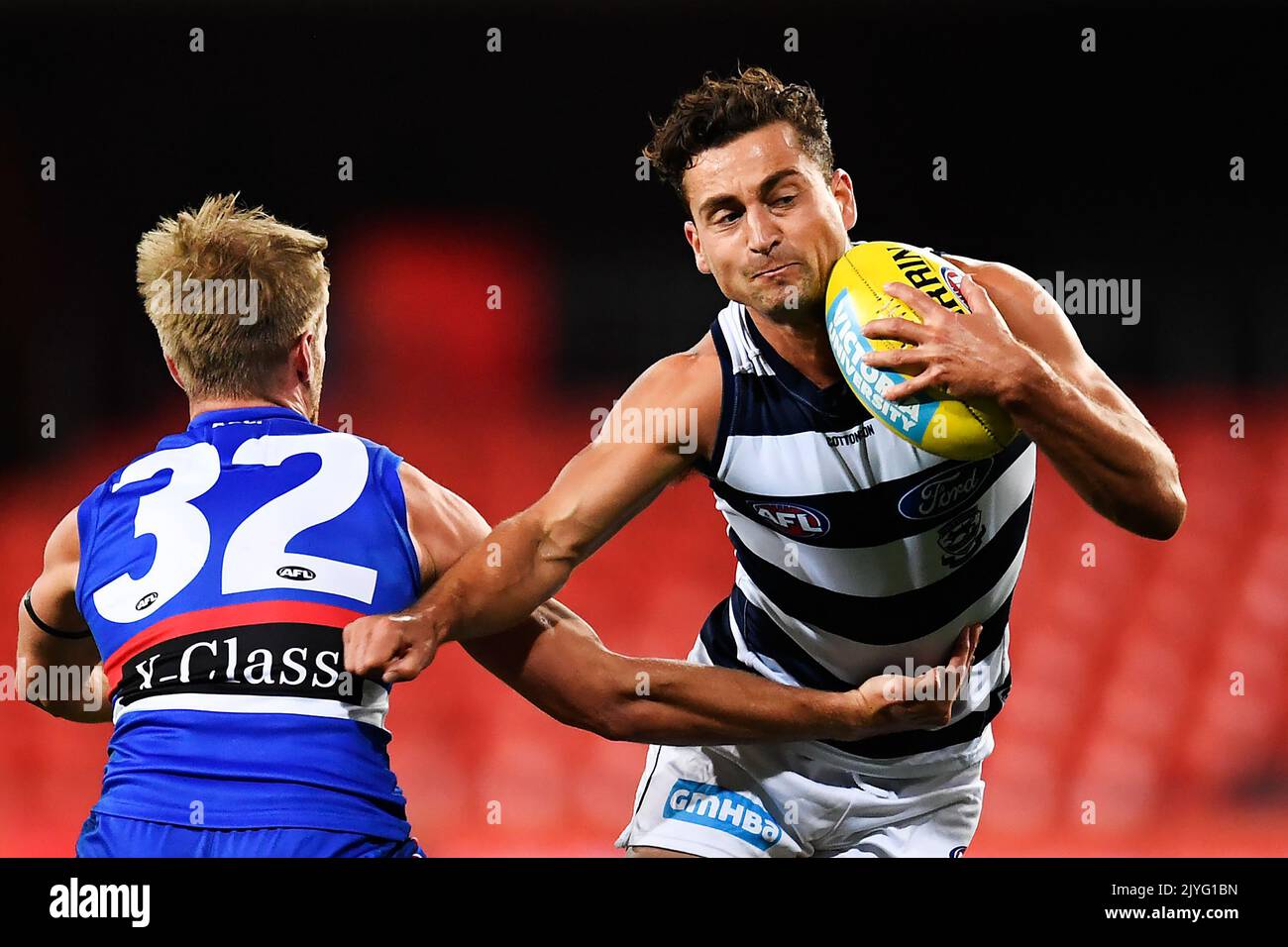 Luke Dahlhaus of the Cats evades the tackle from Will Hayes of the ...
