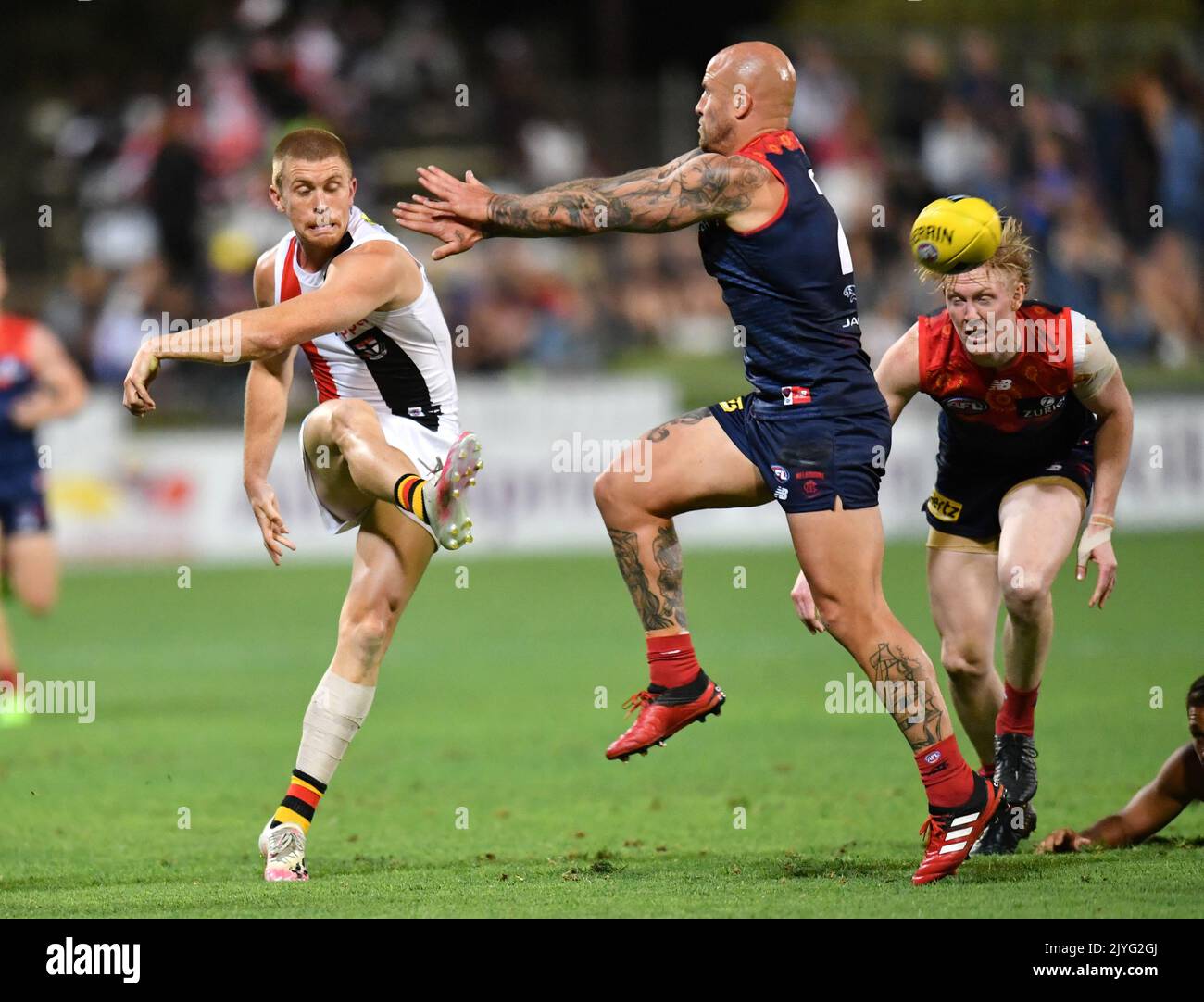 Sebastian Ross (left) of the Saints gets his kick past Nathan Jones ...