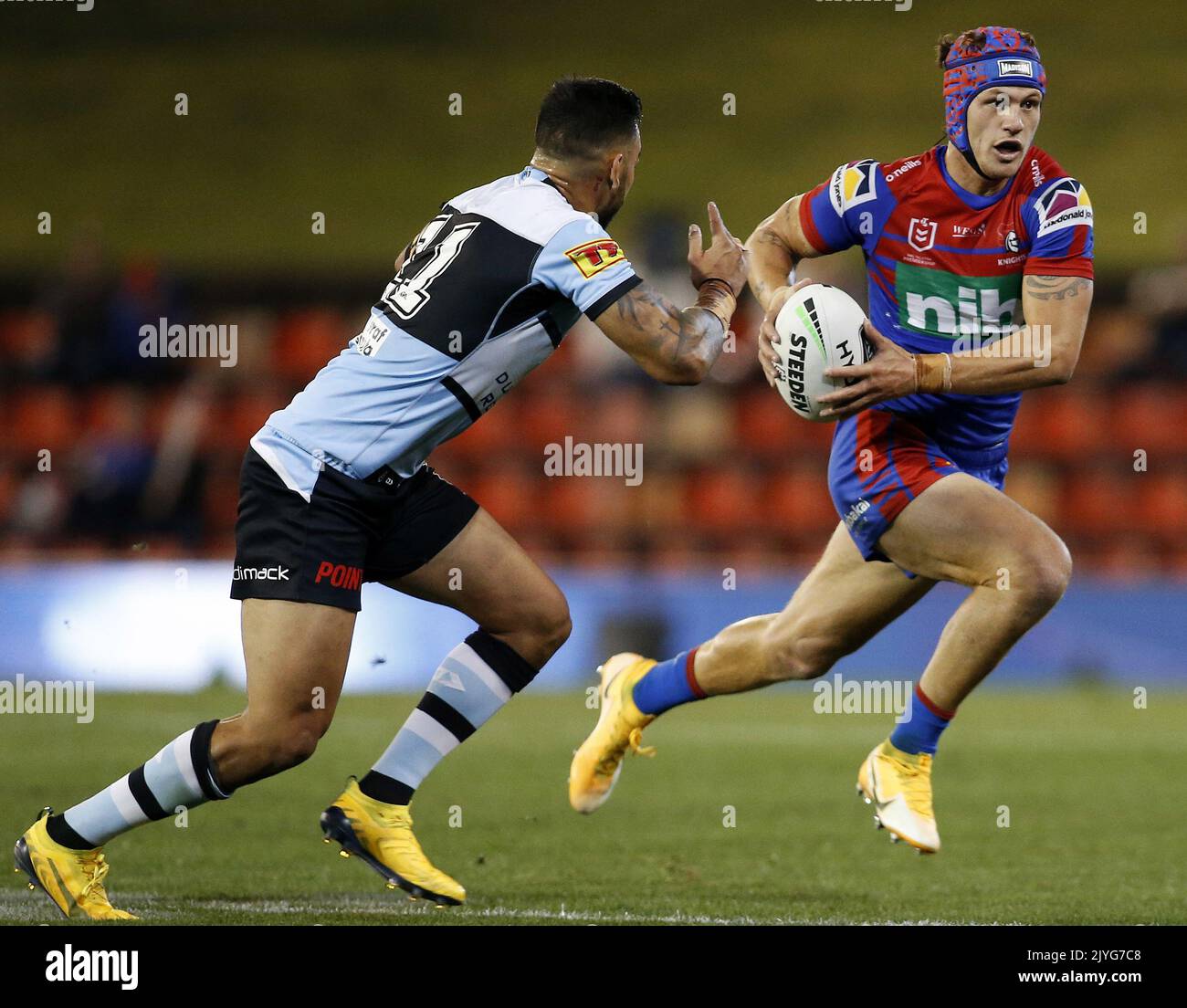 Kalyn Ponga of the Knights evades Briton Nikora of the Sharks during ...