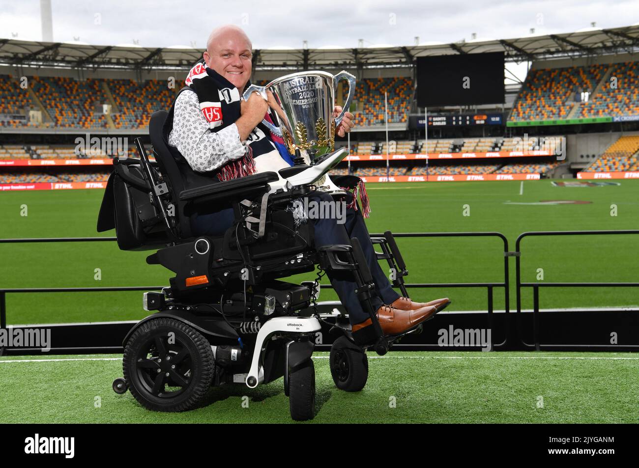 Tim McCallum is seen posing for a photograph with the AFL Premiership ...