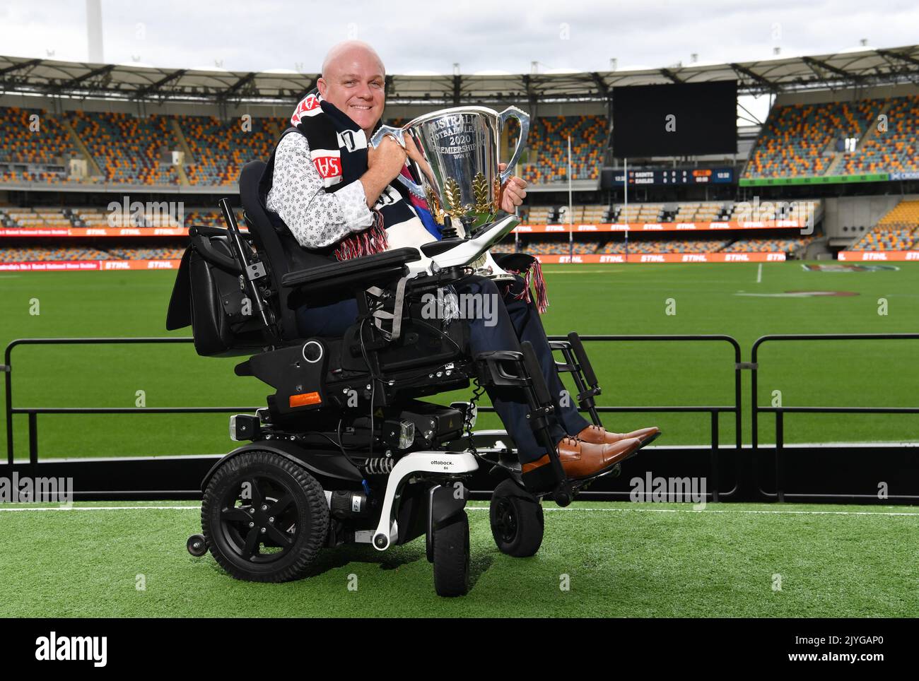Tim McCallum is seen posing for a photograph with the AFL Premiership ...