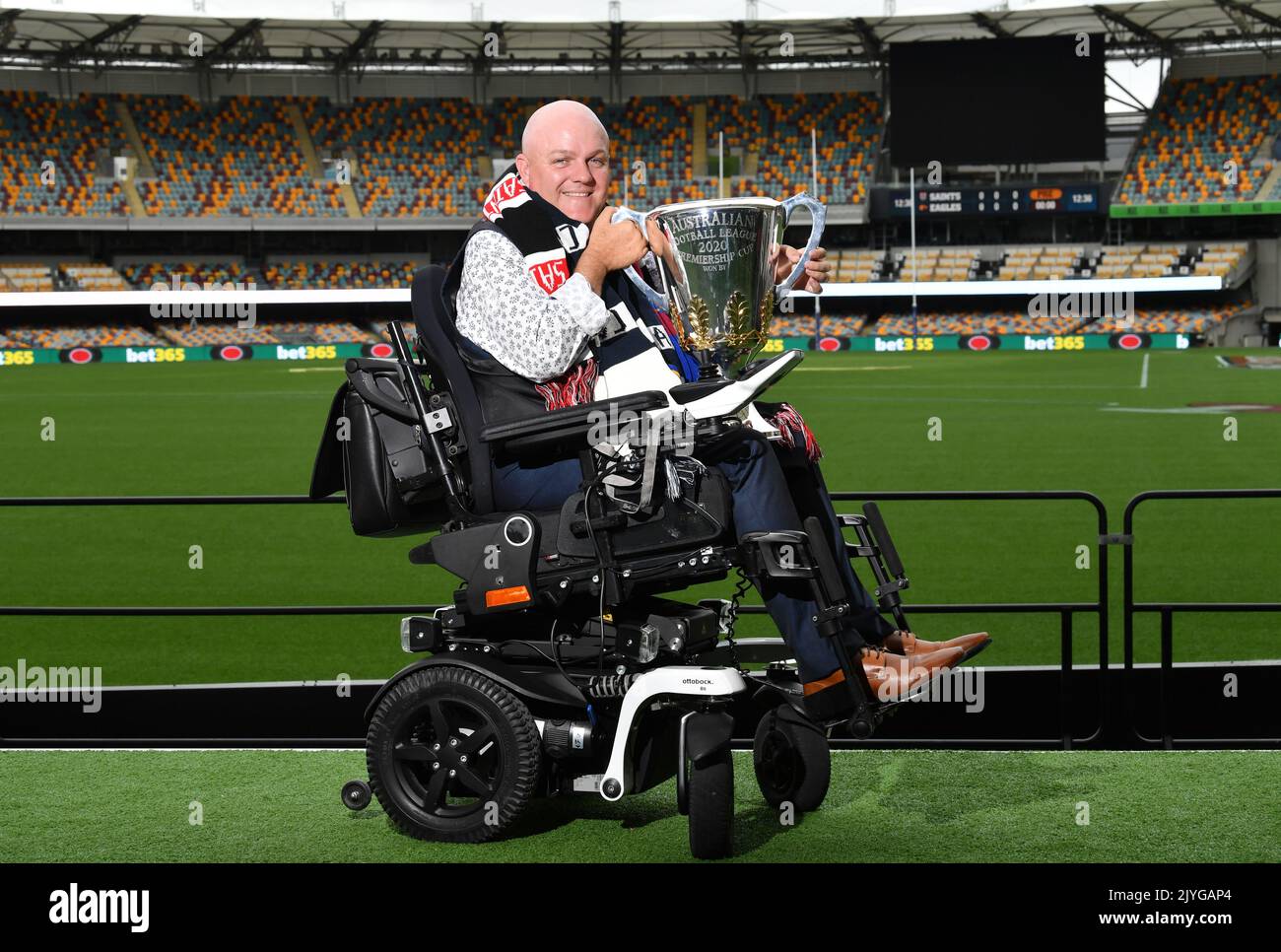 Tim McCallum is seen posing for a photograph with the AFL Premiership ...