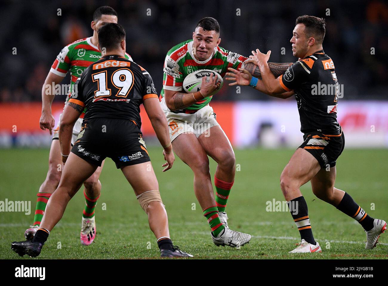 Jaydn Su’a of the Rabbitohs fends off Luke Brooks of the Tigers during ...