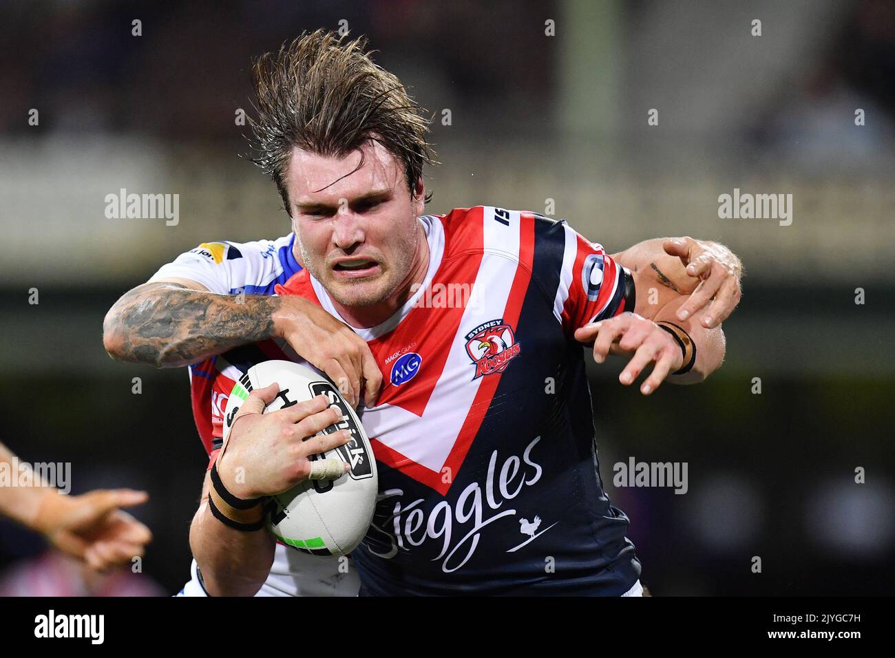 Angus Crichton of the Roosters is tackled by Mitchell Pearce of the ...