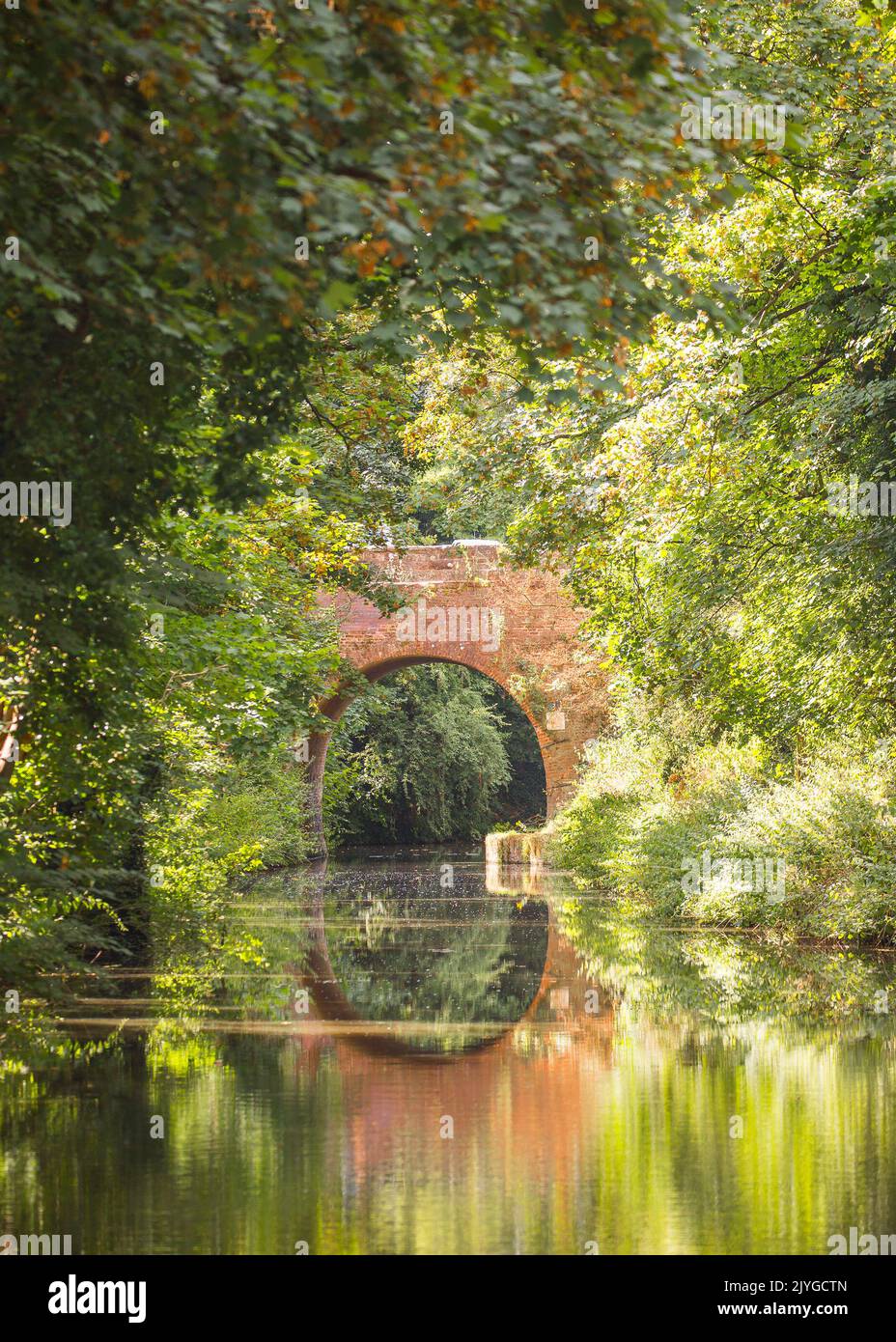 Beautiful reflection of a traditional, English, brick bridge in the ...