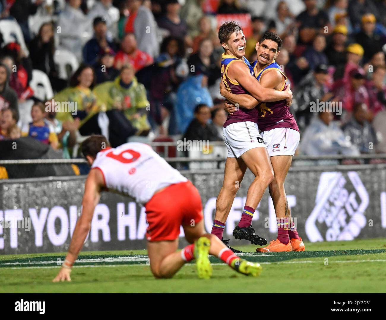 Zac Bailey (centre) of the Lions celebrates kicking a goal with Charlie ...
