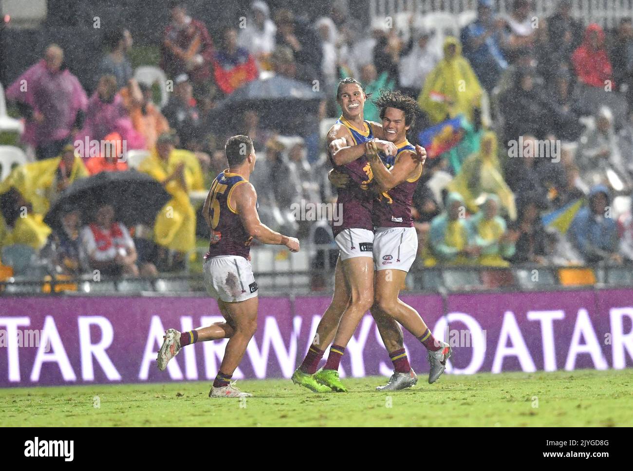 Eric Hipwood (centre) of the Lions celebrates kicking a goal with Dayne ...