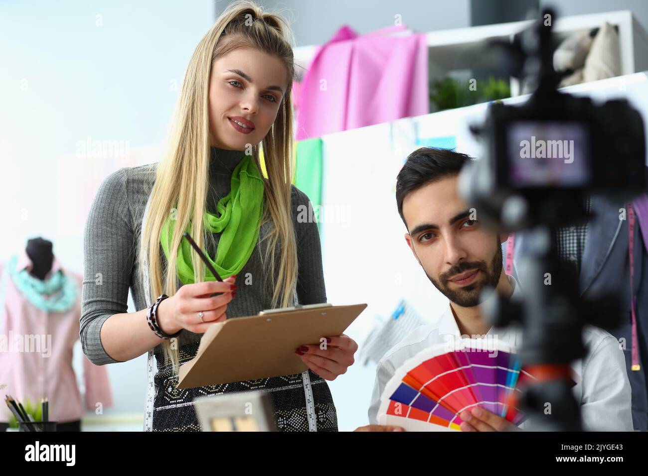 Two young blogger designers are broadcasting on professional camera ...